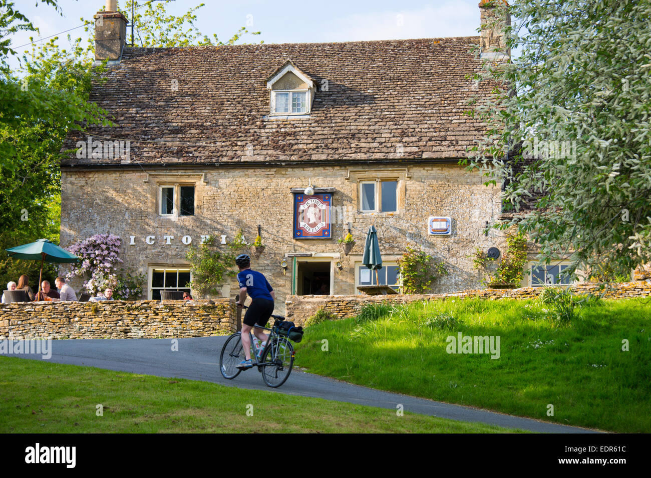 Cyclists cycling past drinkers sitting outside typical English pub The ...