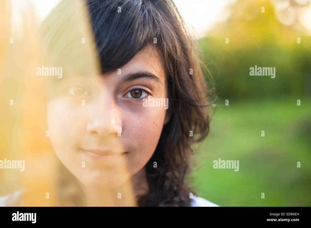 Portrait of a young girl, half of the face is covered by translucent ...