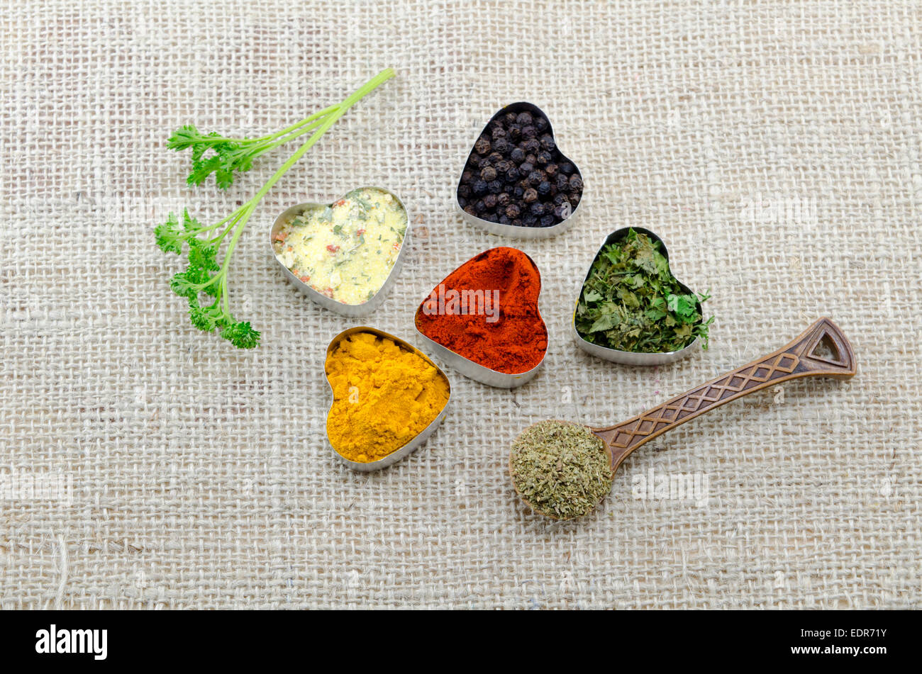 Various spices in heart shaped containers and a spoon Stock Photo - Alamy
