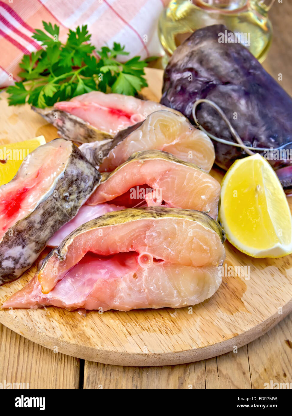 Catfish raw with lemon on board Stock Photo - Alamy