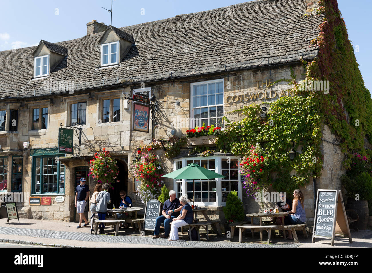 Tourists drinking at The Cotswolds Arms inn traditional old gastro pub ...