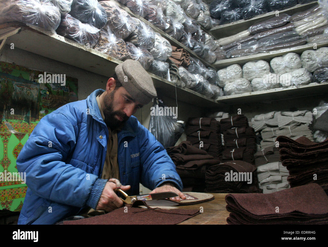 Peshawar. 9th Jan, 2015. A man knits a traditional cap inside a shop at ...