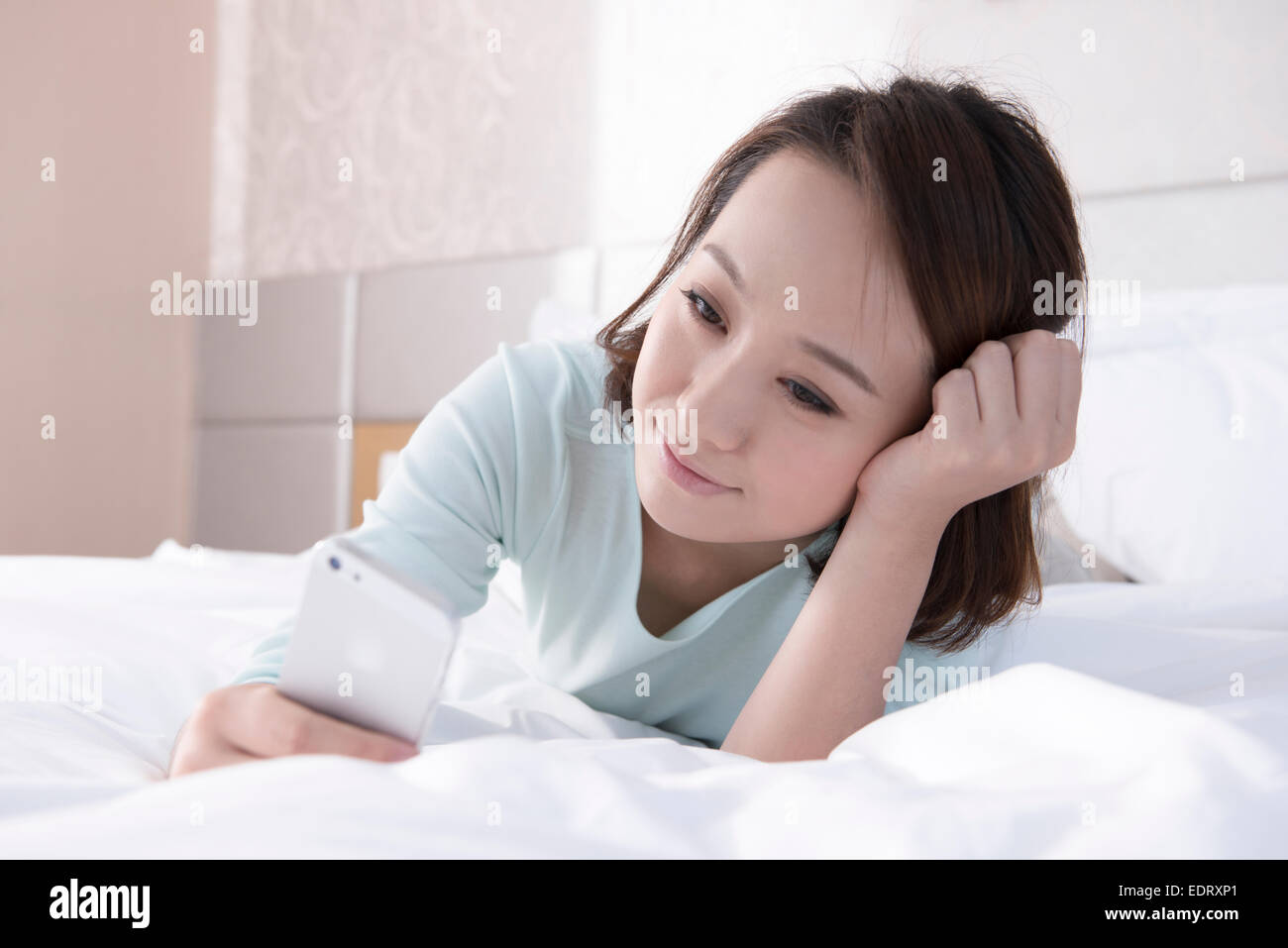 Young woman using smart phone in bed Stock Photo - Alamy