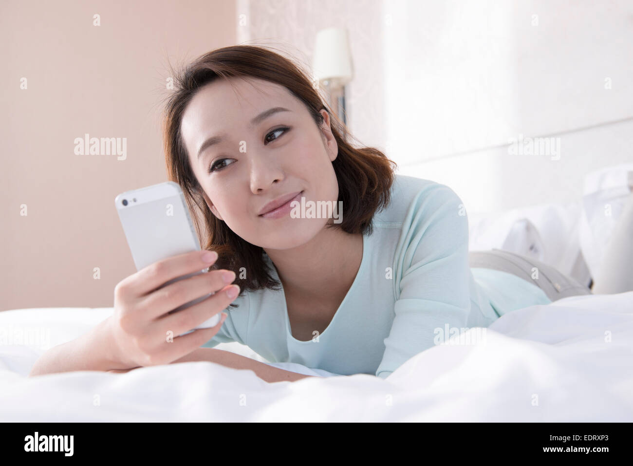 Young woman using smart phone in bed Stock Photo - Alamy