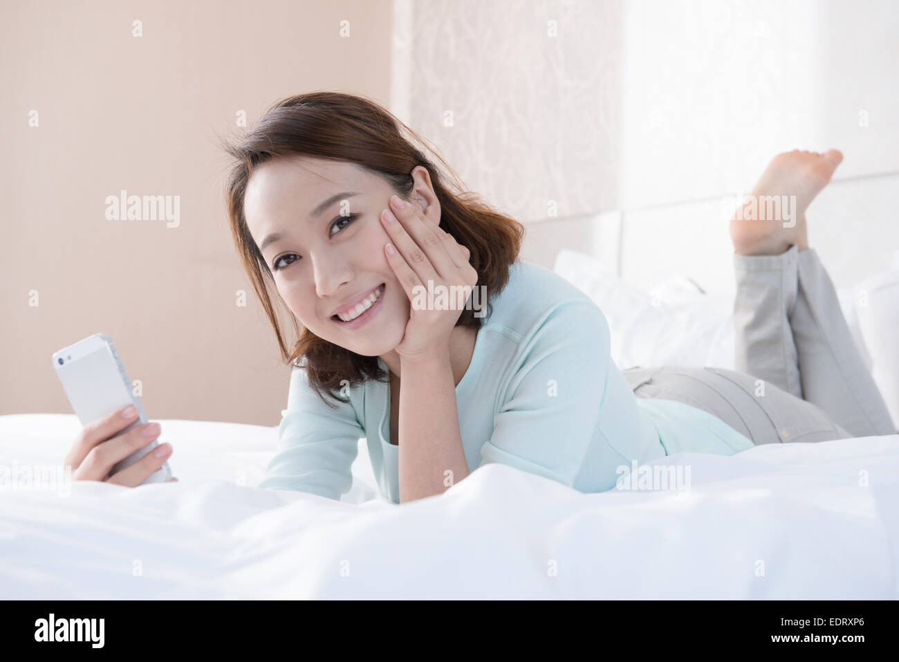 Young woman using smart phone in bed Stock Photo - Alamy