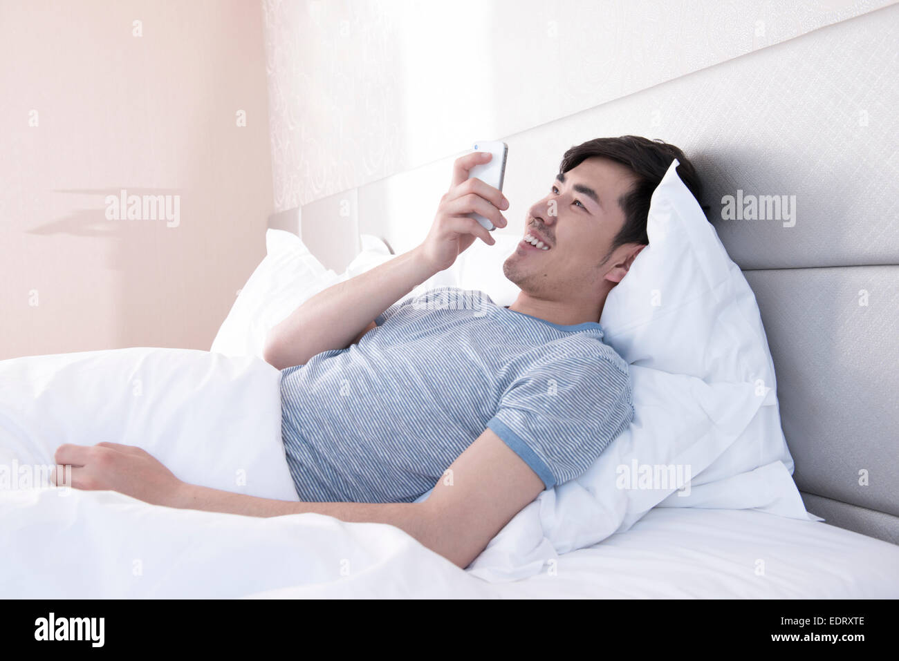 Man lying in bed hands behind head hi-res stock photography and images ...