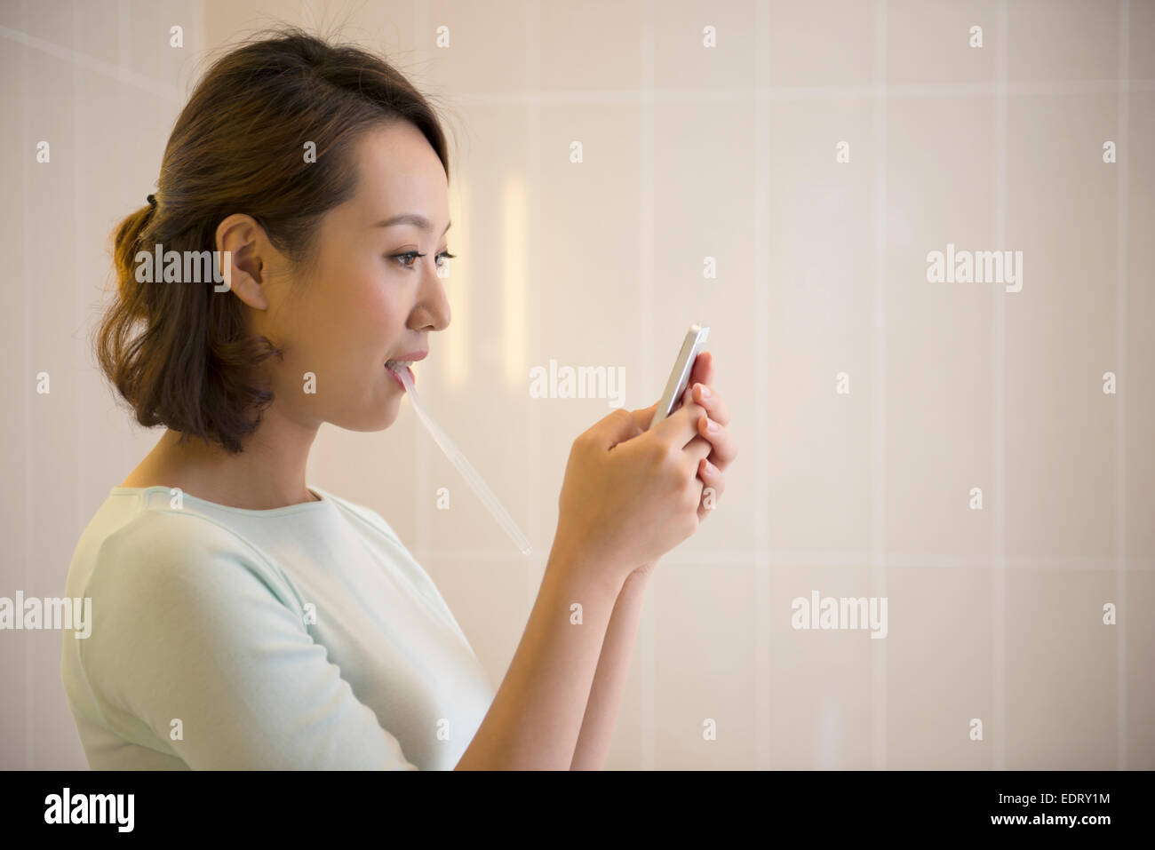 Young woman texting in bathroom Stock Photo - Alamy