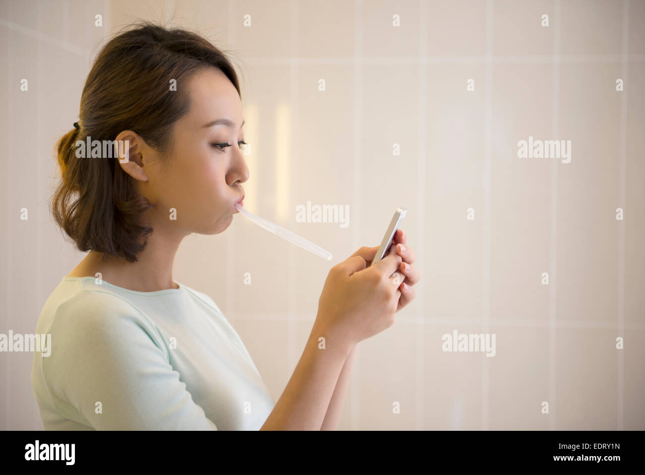 Young woman texting in bathroom Stock Photo - Alamy