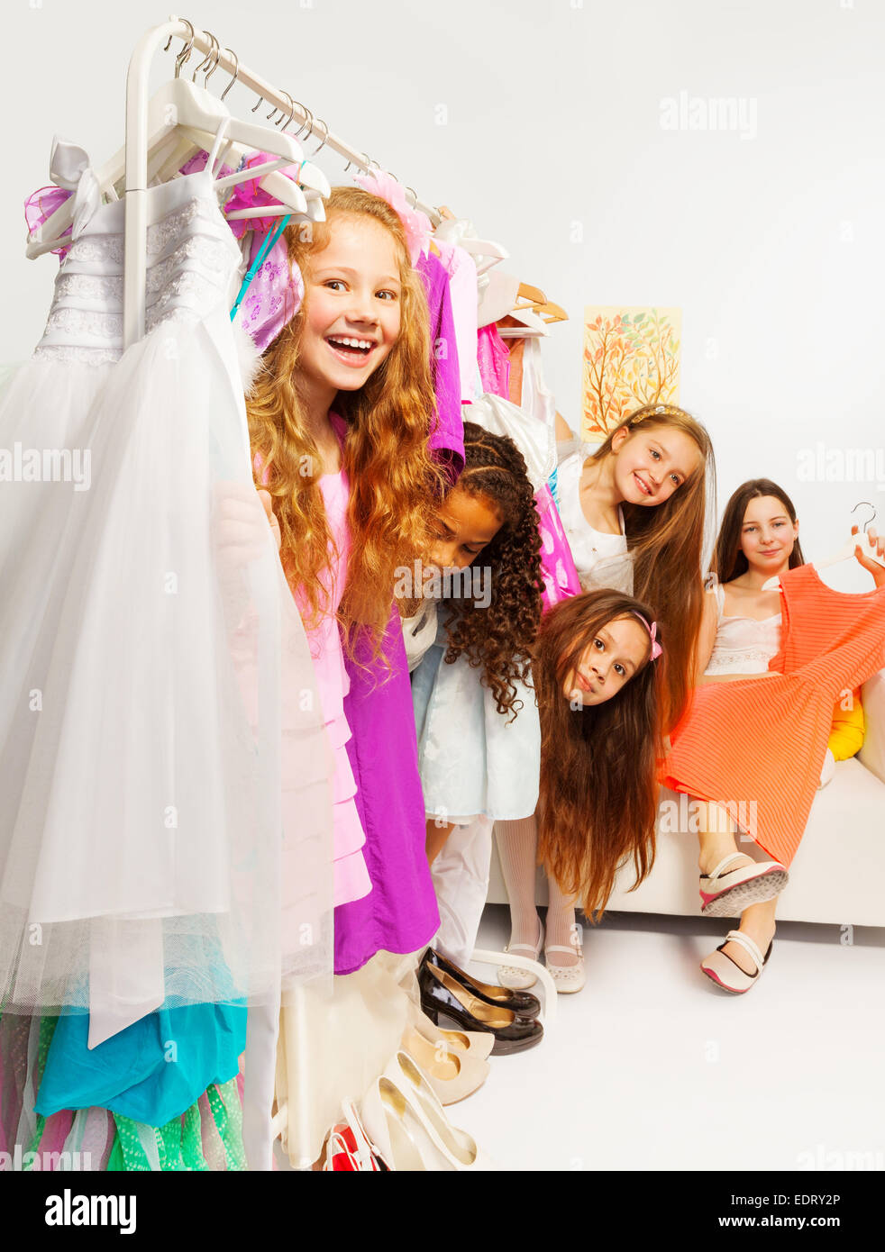 Positive girls during shopping behind hangers Stock Photo - Alamy