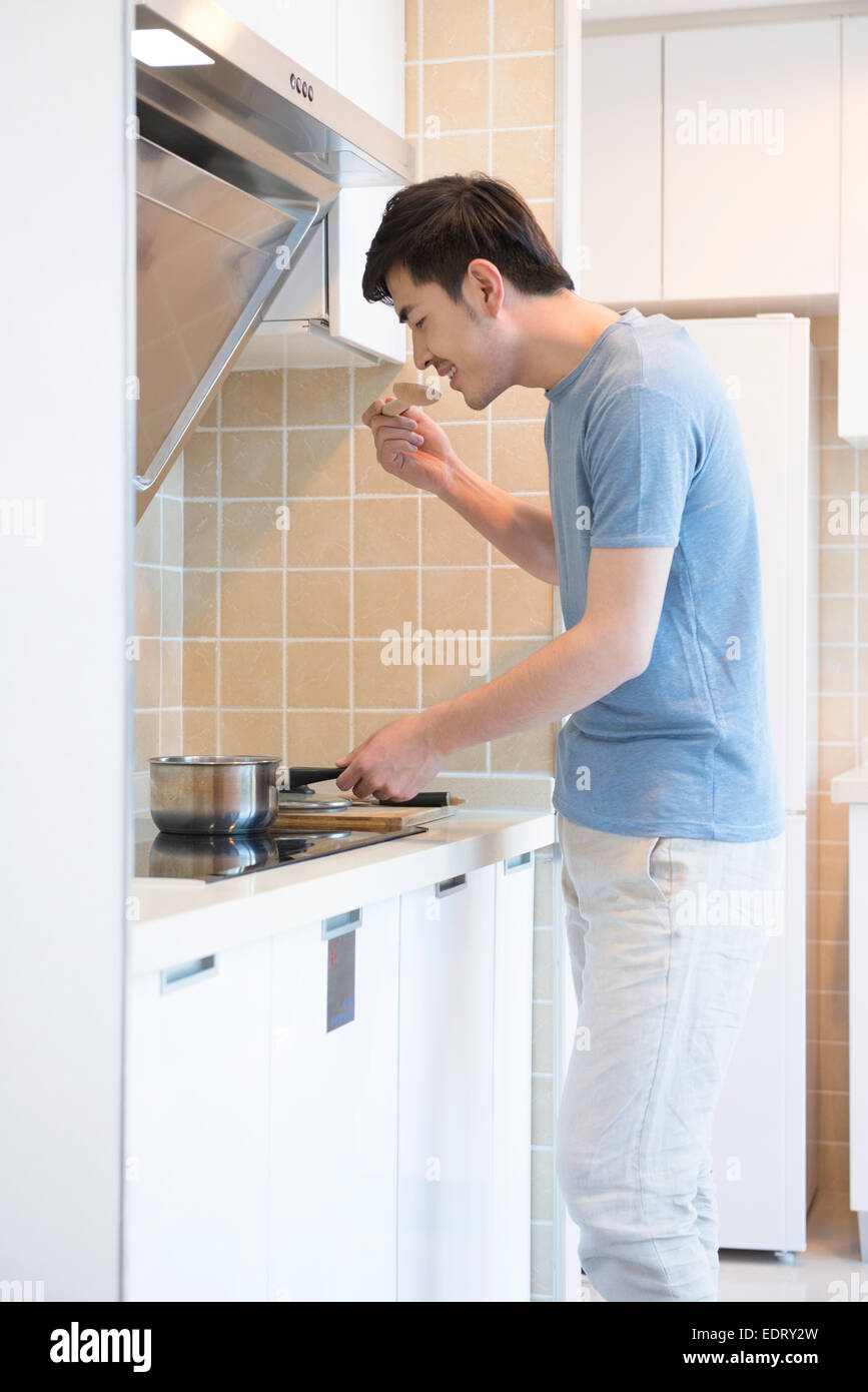Young man cooking in kitchen Stock Photo - Alamy