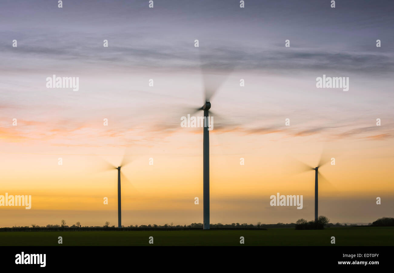 Modern wind turbines in field, previously RAF WW2 airfield, at sunset ...