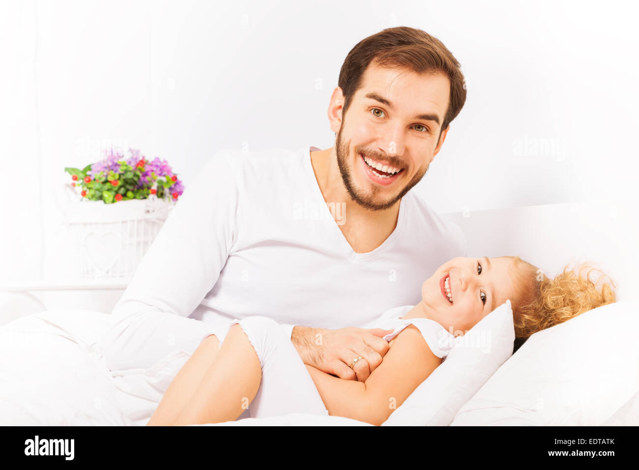 Father hugs cute daughter and laying on bed Stock Photo - Alamy