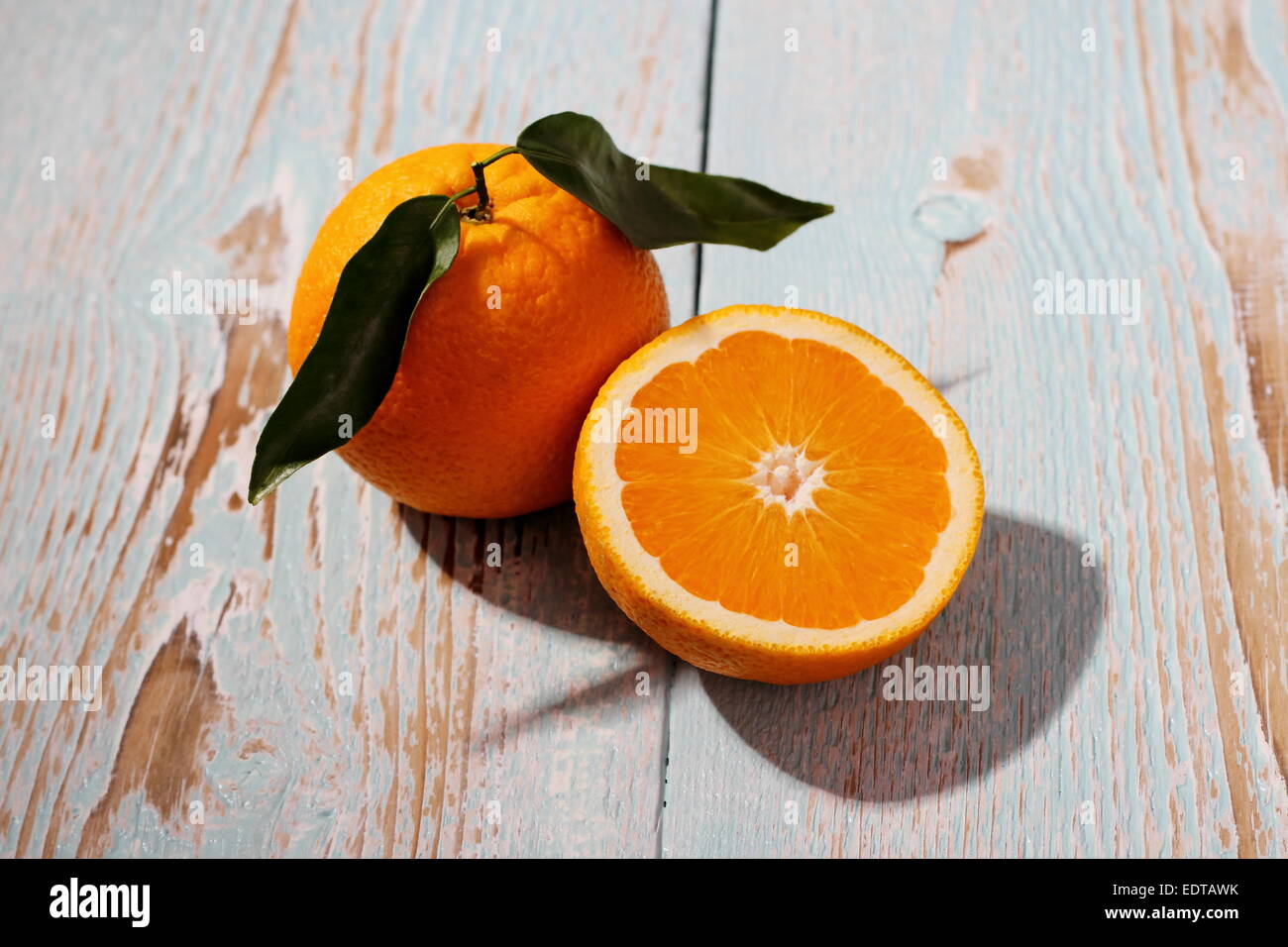 Two big ripe orange fruit with leaf on wooden board, top view Stock ...