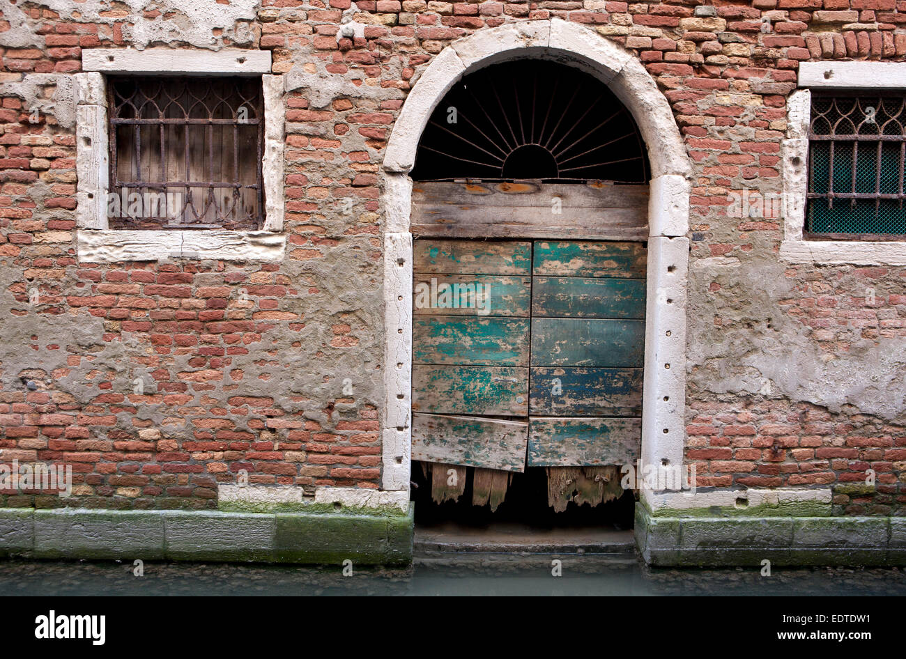 An old doorway next to a canal in the back streets of Venice Italy ...