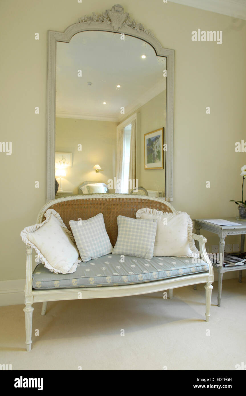 Small settee with large mirror, UK Stock Photo - Alamy