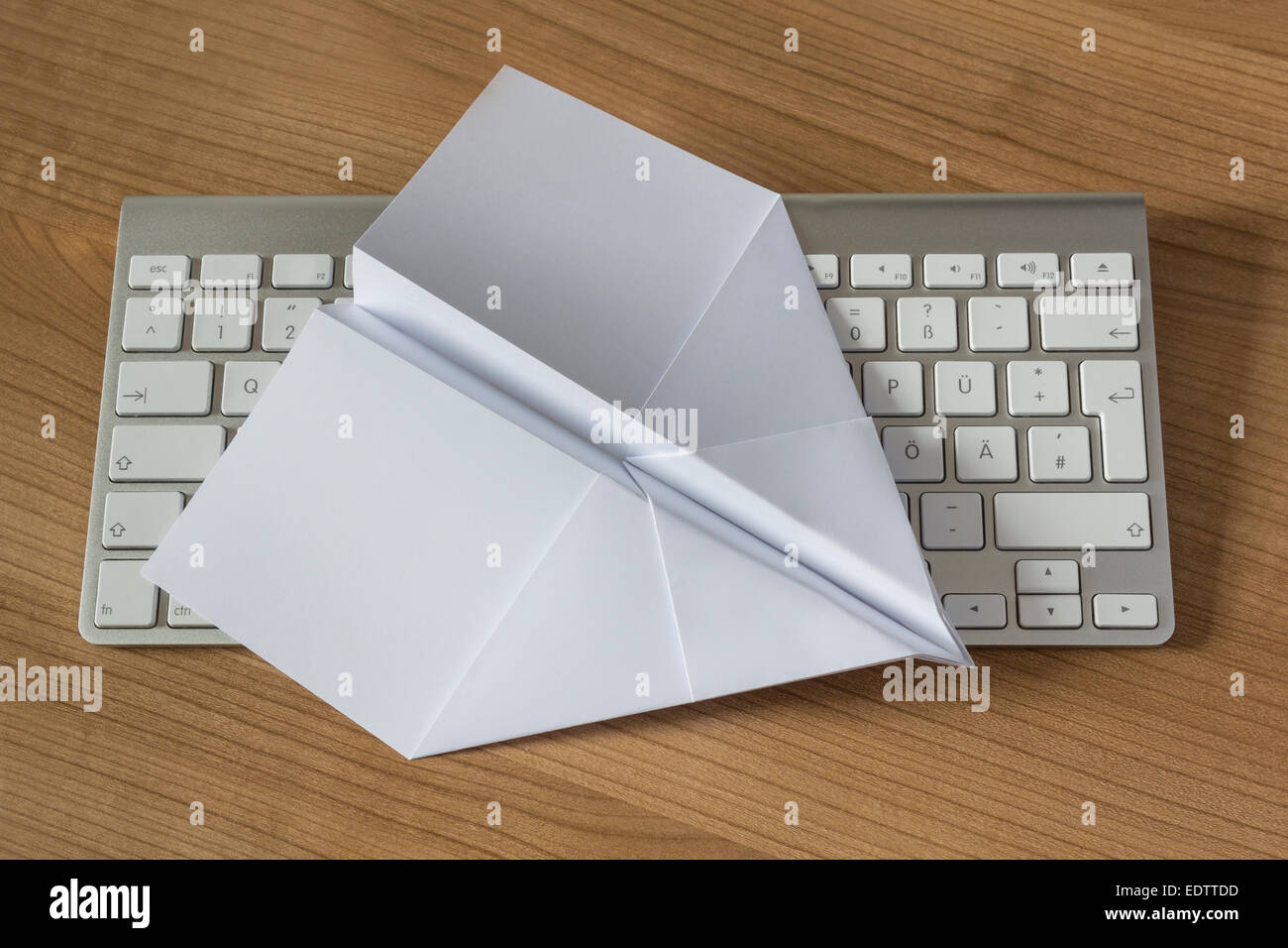 Paper Airplane on a wooden office desk with modern keyboard Stock Photo ...
