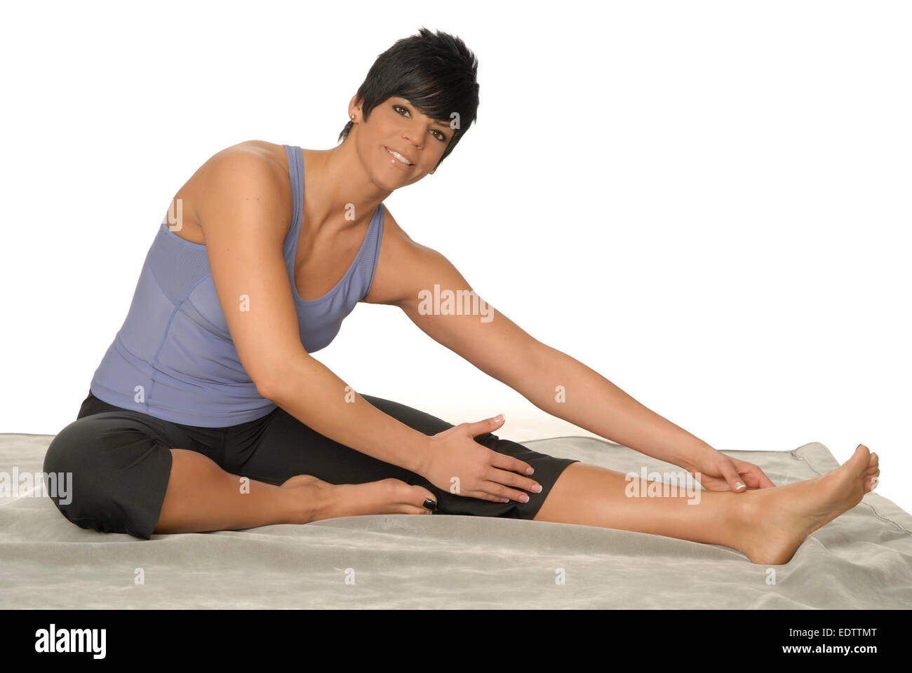 Woman in exercise clothes on mat, stretching Stock Photo - Alamy
