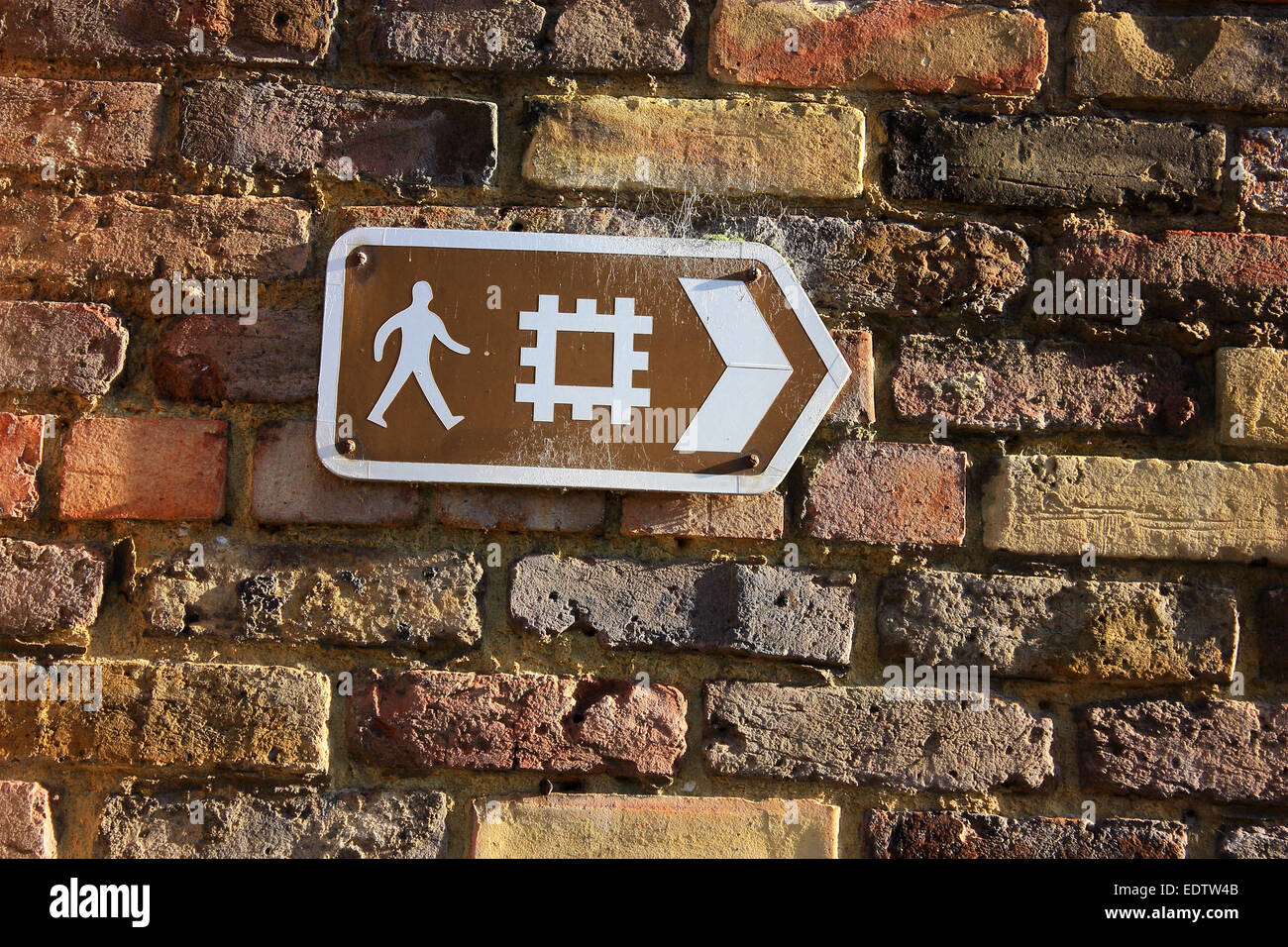 A public footpath sign mounted on a brick wall Stock Photo - Alamy