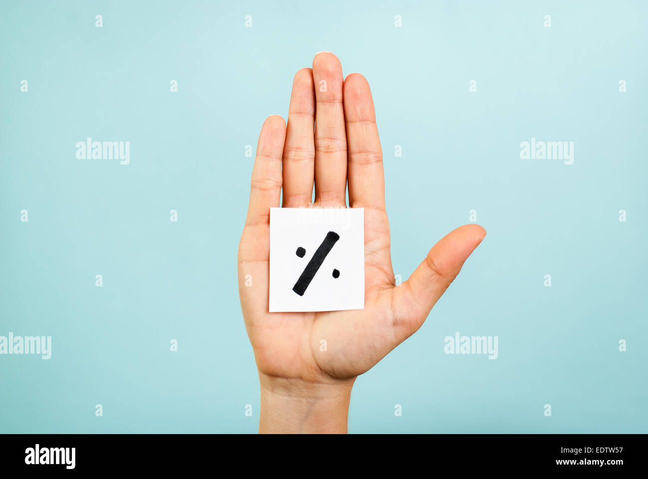 Hand with percentage symbol on blue background Stock Photo - Alamy