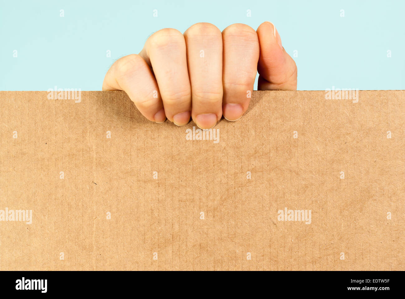 Hand showing a blank cardboard message on blue background Stock Photo ...