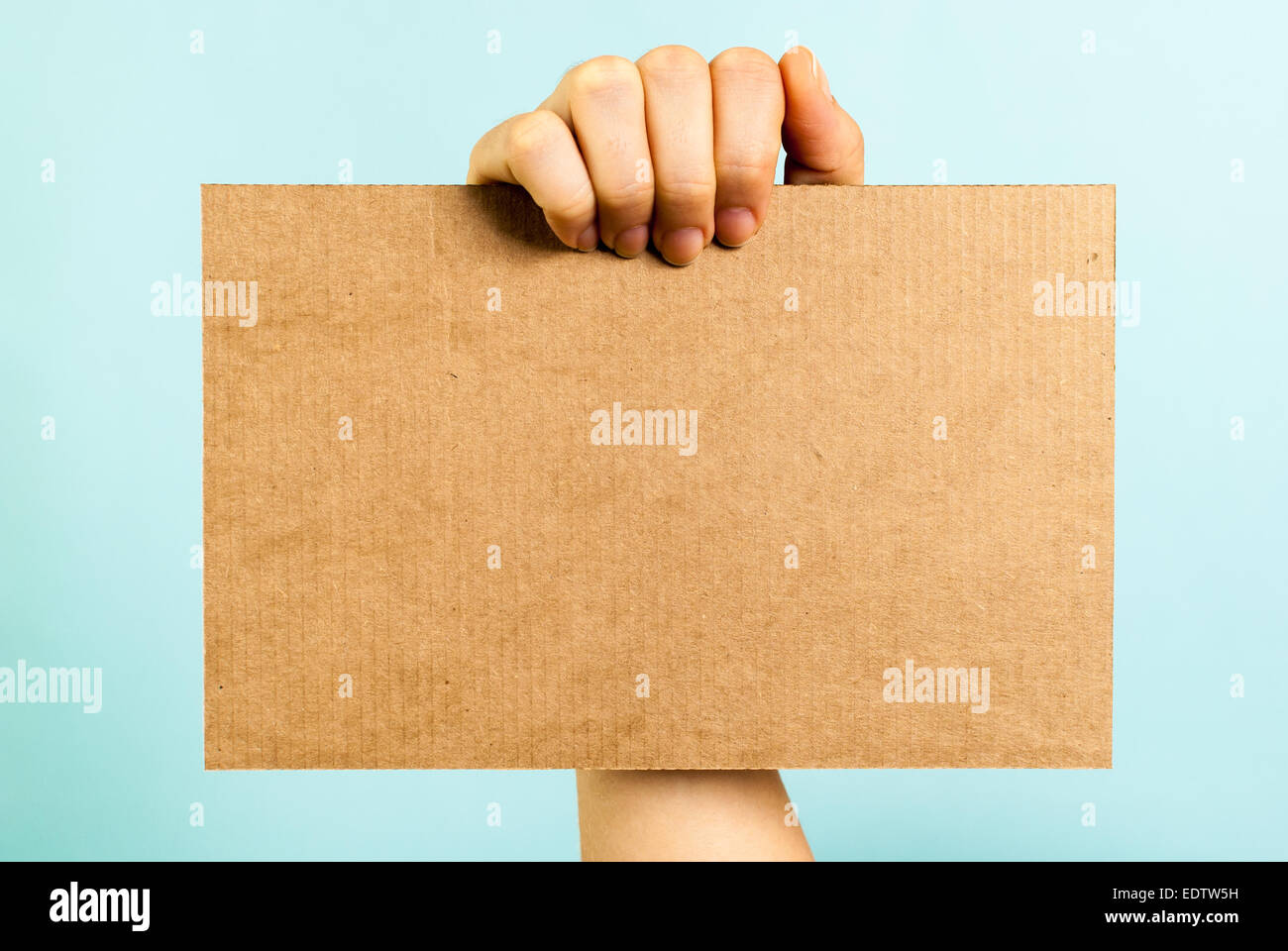 Hand up showing a blank cardboard message on blue backgroun Stock Photo ...