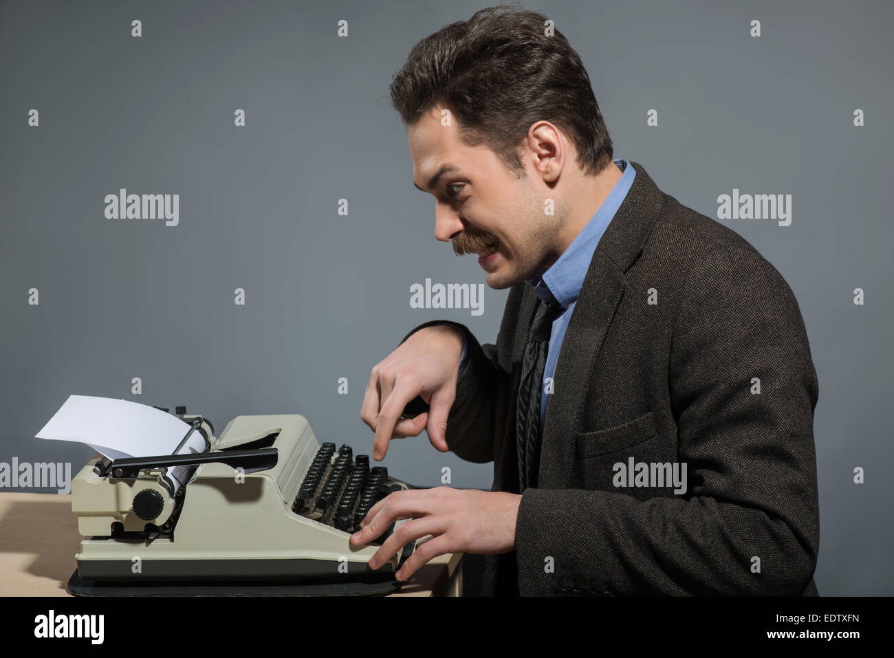 Happy young author typing at typewriter Stock Photo - Alamy