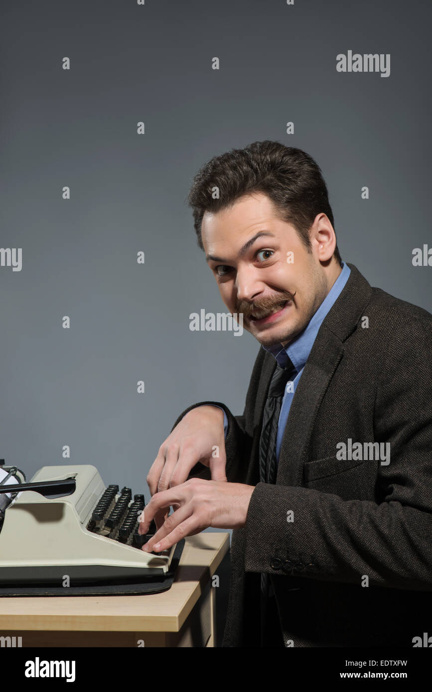 Happy young author typing at typewriter Stock Photo - Alamy