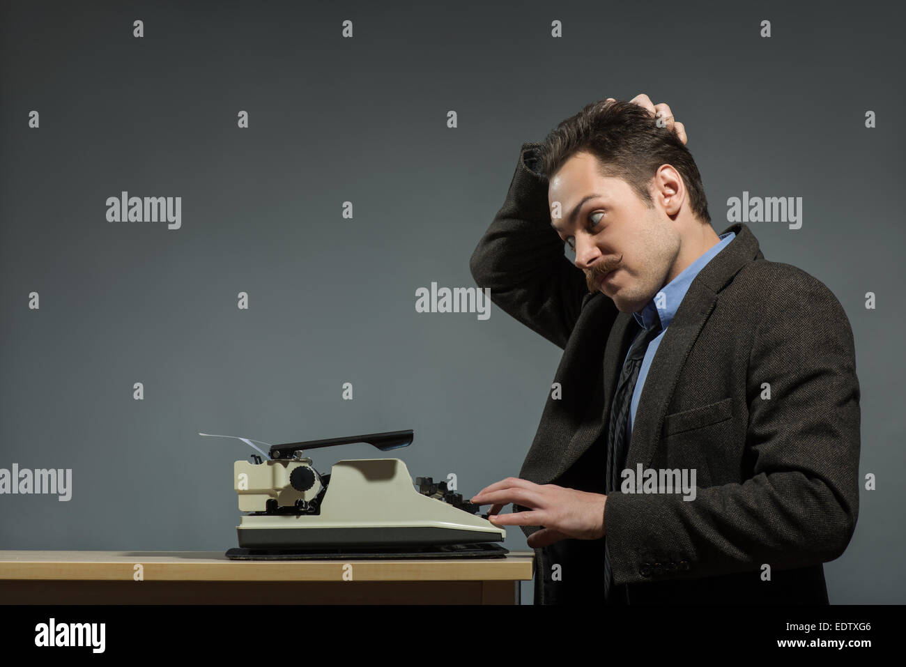Happy young author typing at typewriter Stock Photo - Alamy