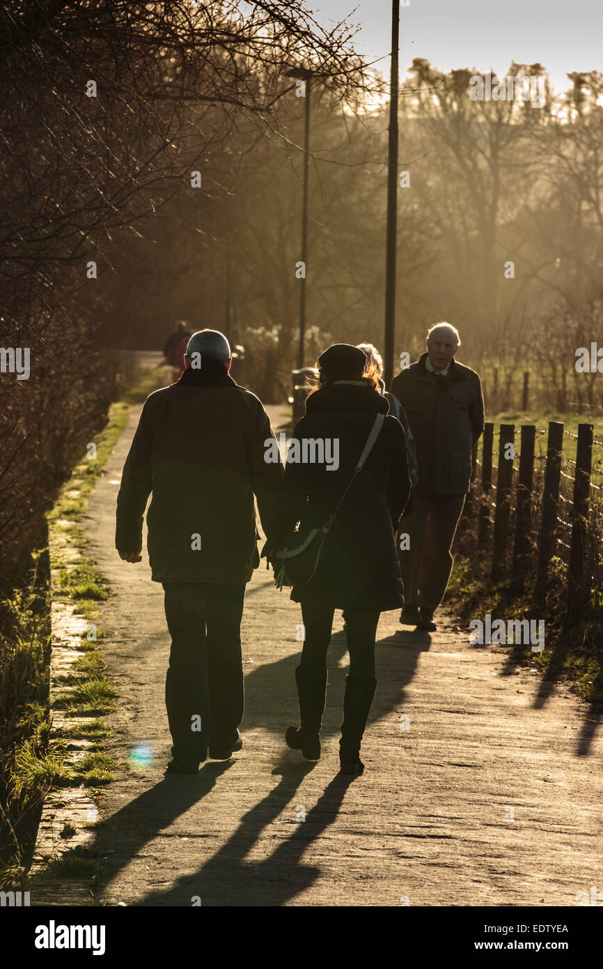 Two couples walking along Town Path near Salisbury Cathedral. Warm ...