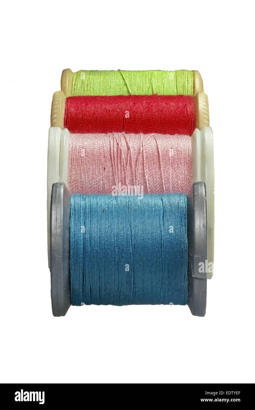 Cut out of blue, pink, red and green cotton reels lined up in a row ...