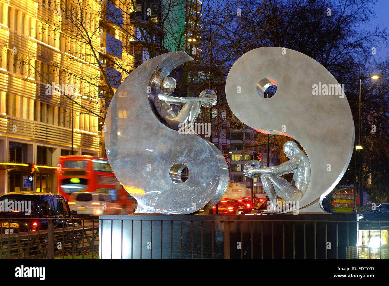 Yin Yang metal sculpture at night on Park Lane, London Stock Photo - Alamy