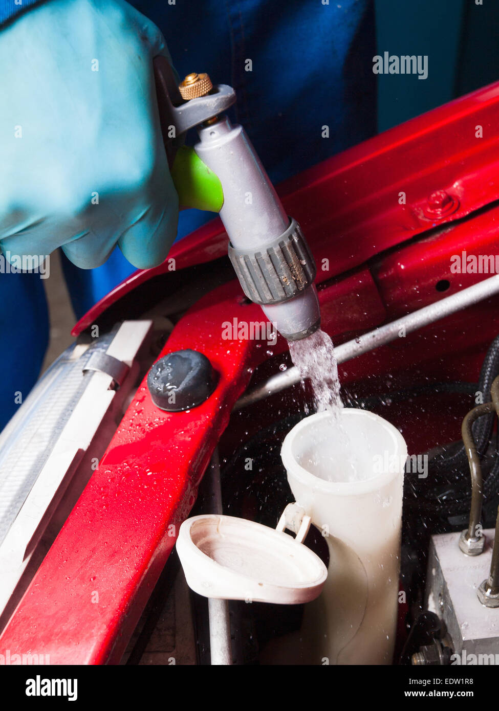 Man filling the water tank of the car in a garage Stock Photo - Alamy