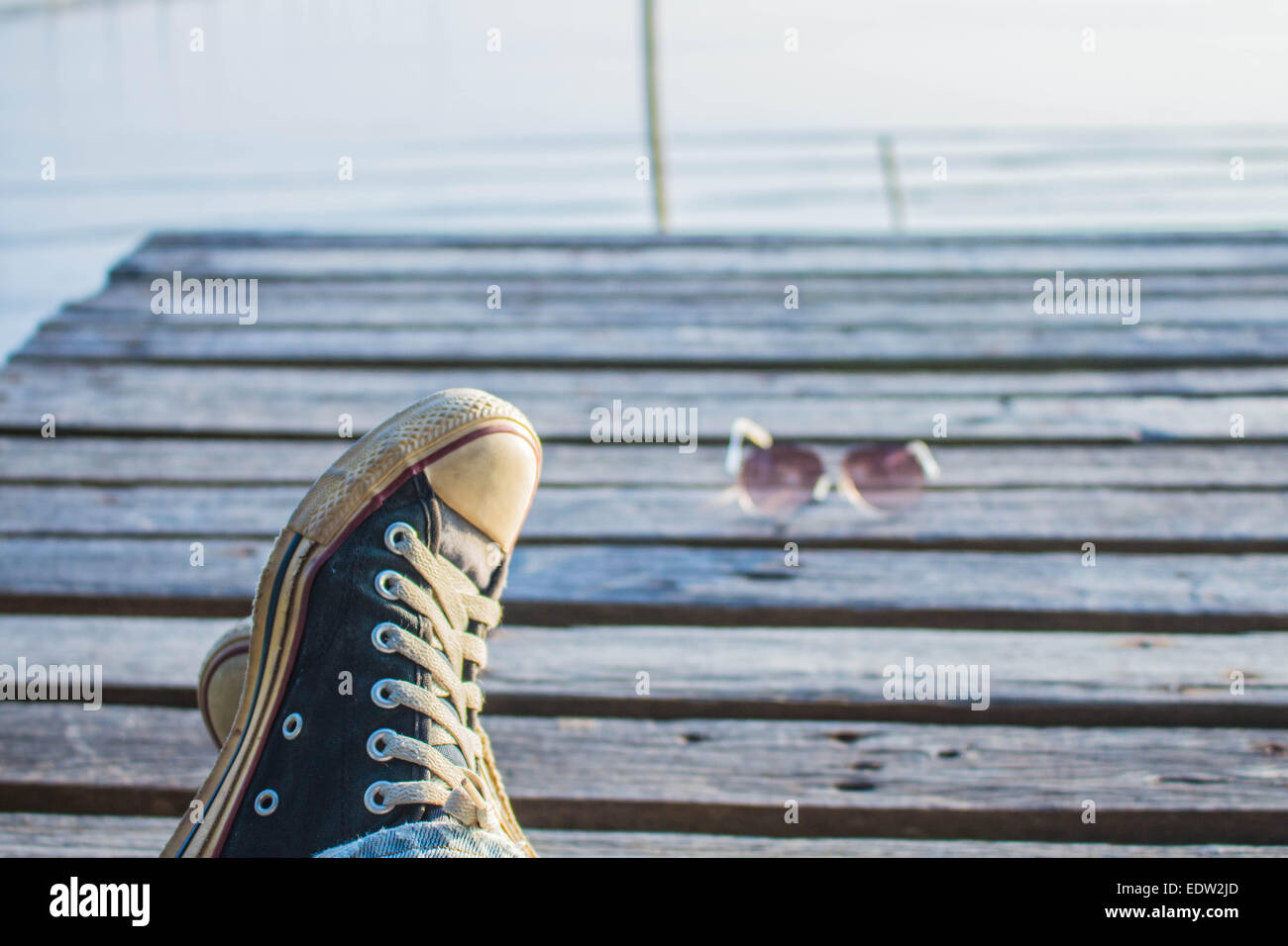 Wear sneakers and glasses on a wooden floor Stock Photo - Alamy