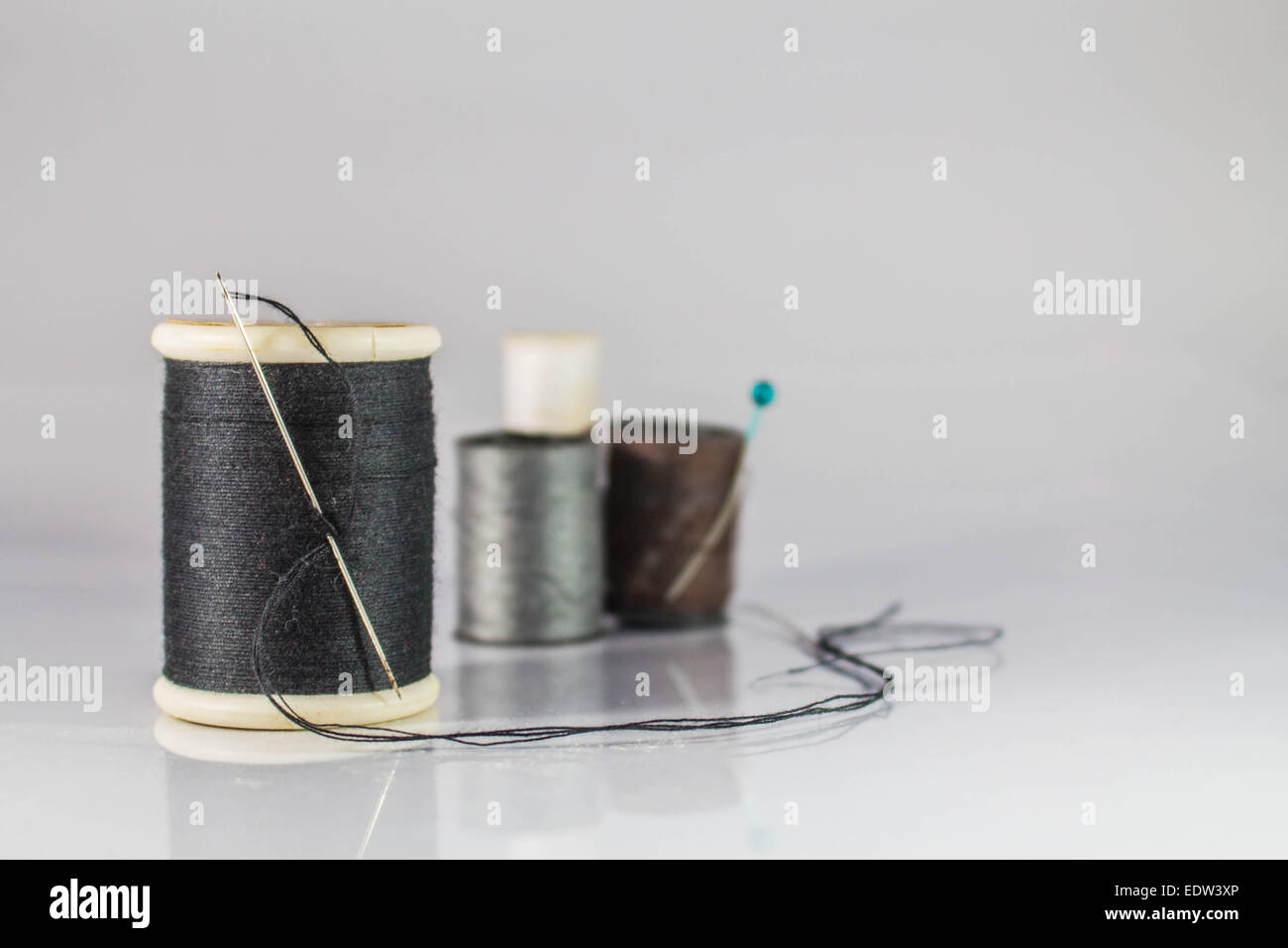 Black thread rolling on the floor Stock Photo - Alamy