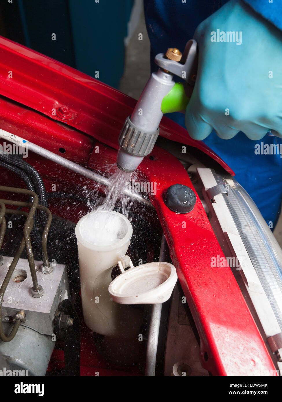 Man filling the water tank of the car in a garage Stock Photo - Alamy