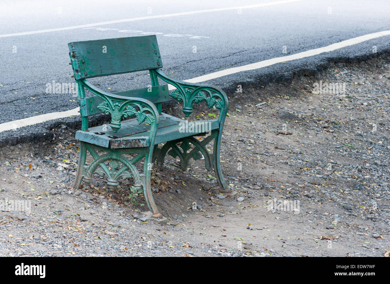 Lonely bench near the street in urban park Stock Photo - Alamy