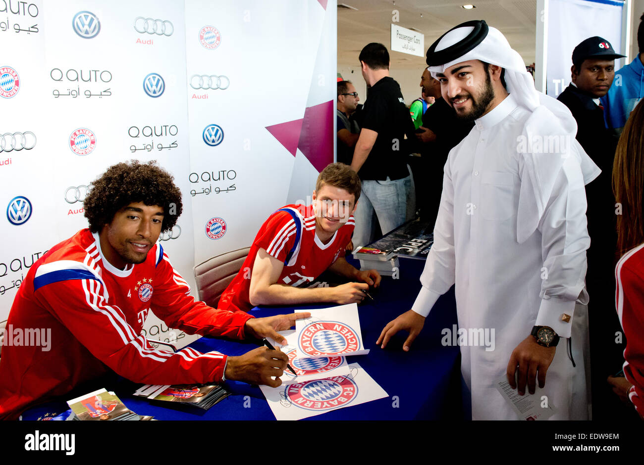 Munich's players Dante (L) and Thomas Mueller give autographs to fans ...
