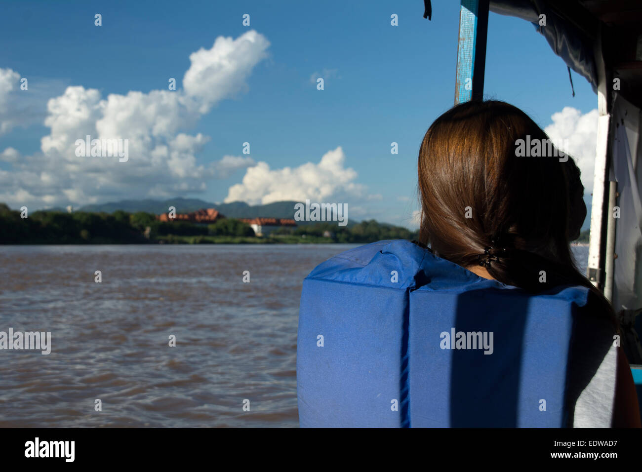 A tourist on a long boat on the Mekong River, in the Golden Triangle in ...