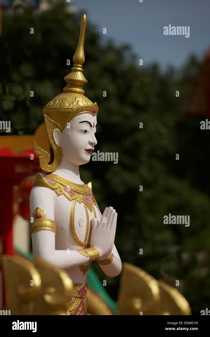 Buddhist statue with hands clasped in prayer. Illuminated statue ...