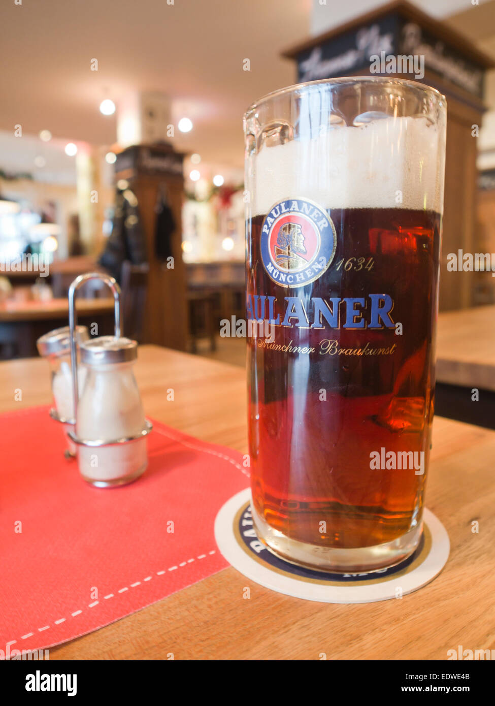 Foaming dark Paulaner beer on a restaurant table in Hamburg German ...