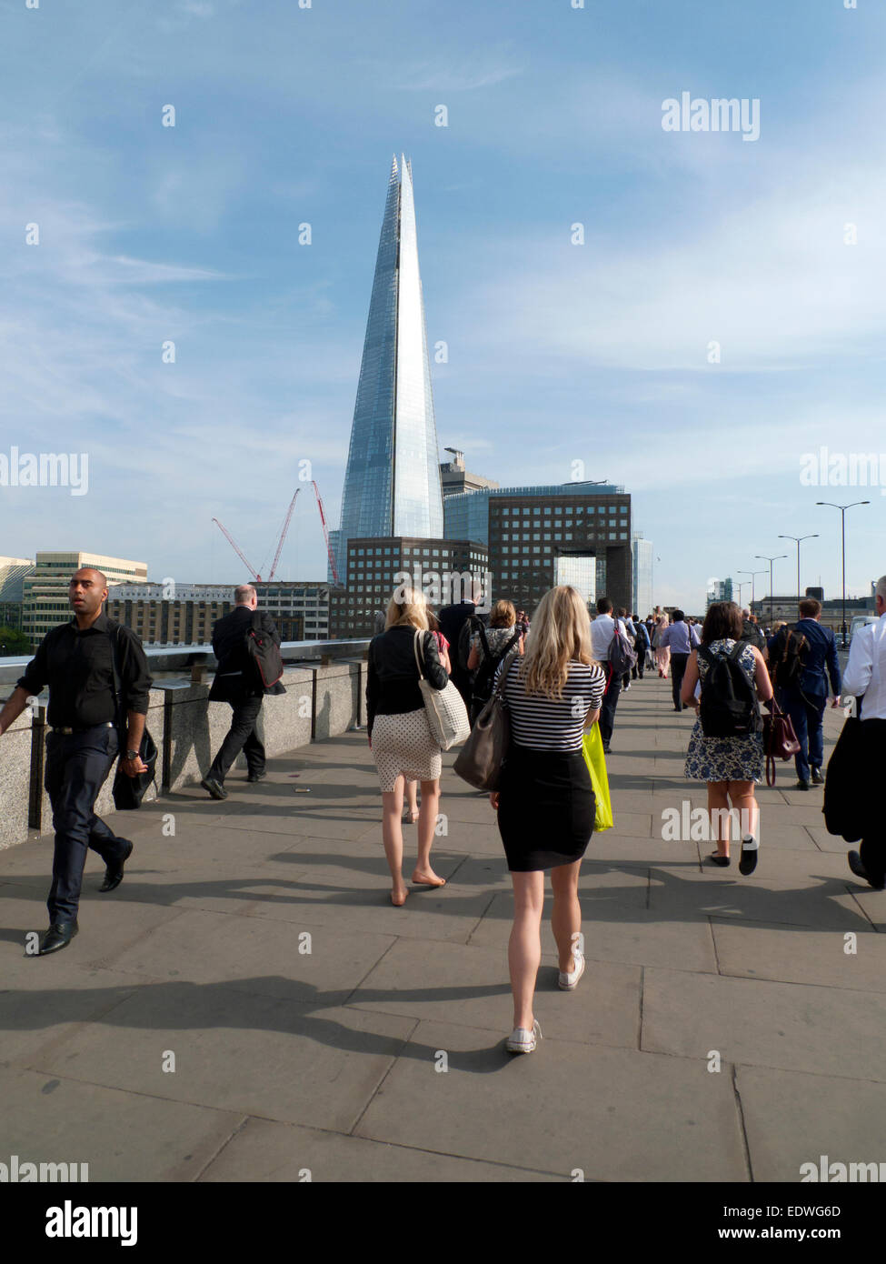 City of London office workers walking across London Bridge after work ...