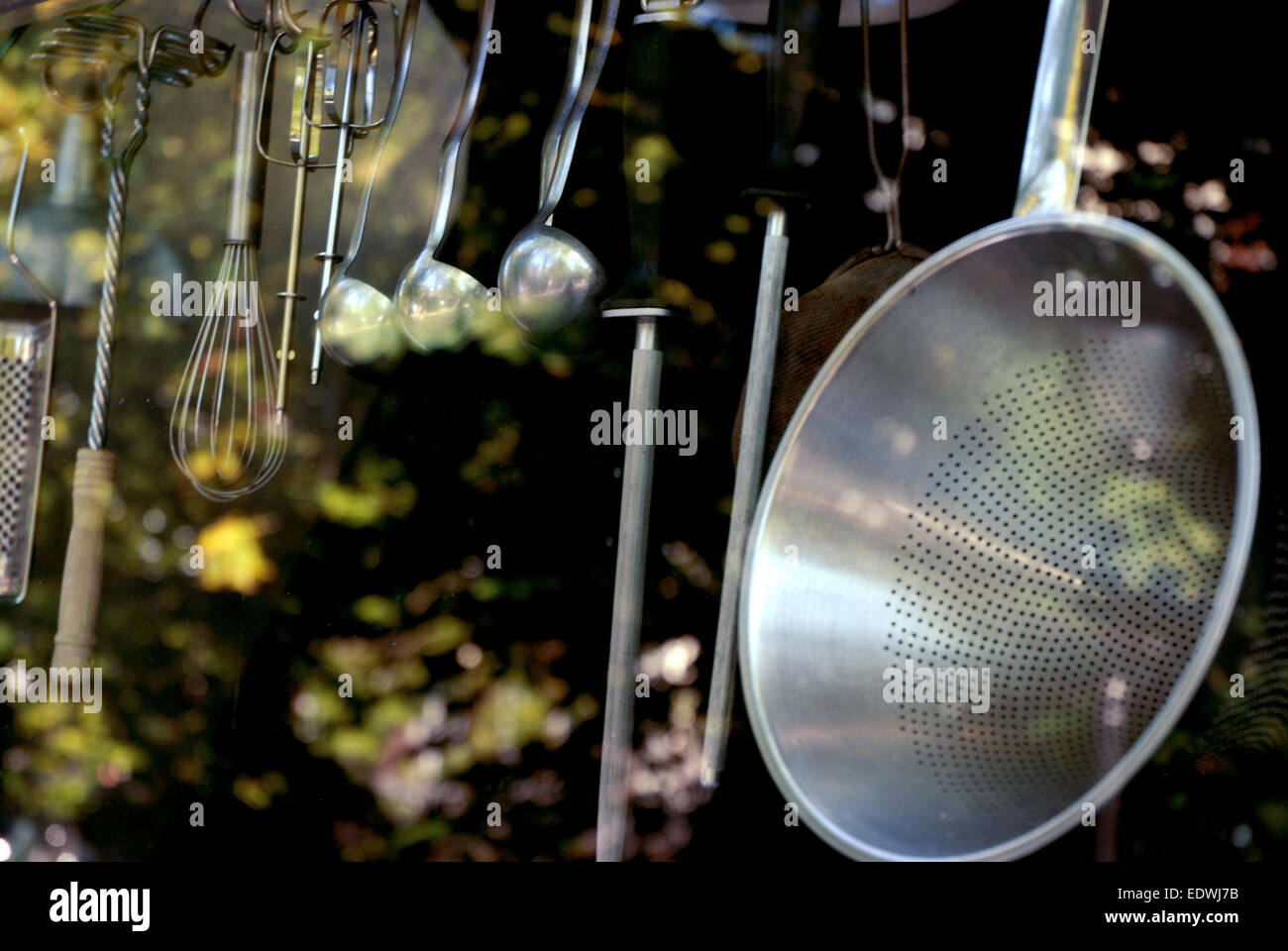 Kitchen implements / Cooking utensils hanging in window Stock Photo - Alamy