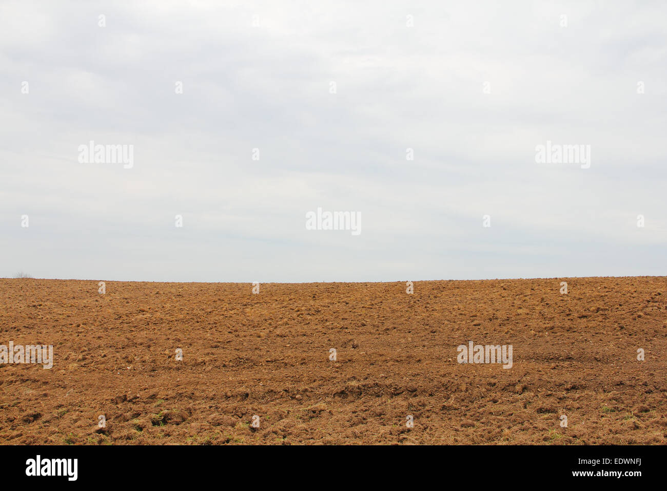 Dry plowed earth agricultural land hill and sky background Stock Photo ...
