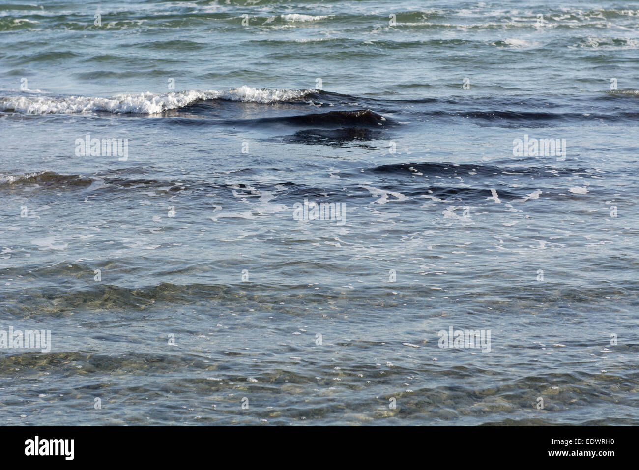 Small waves and shallow water pattern on a beach Stock Photo - Alamy