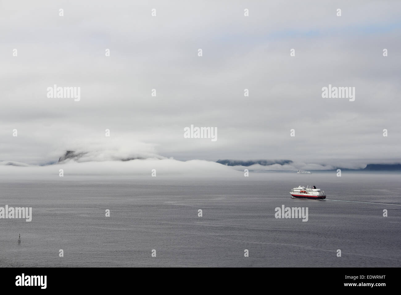 Morning fjord landscape with mountains and fog over water and ship ...