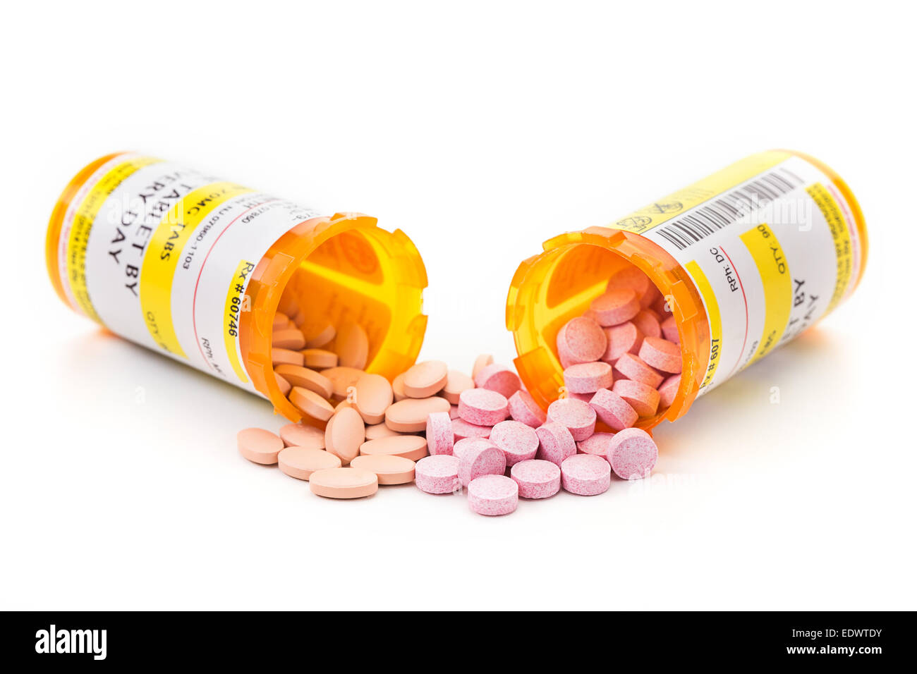 Prescription medication cascading out of orange pharmacy vials isolated ...