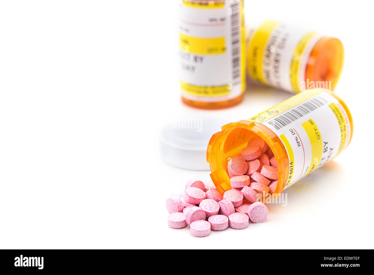 Prescription medication cascading out of orange pharmacy vials isolated ...