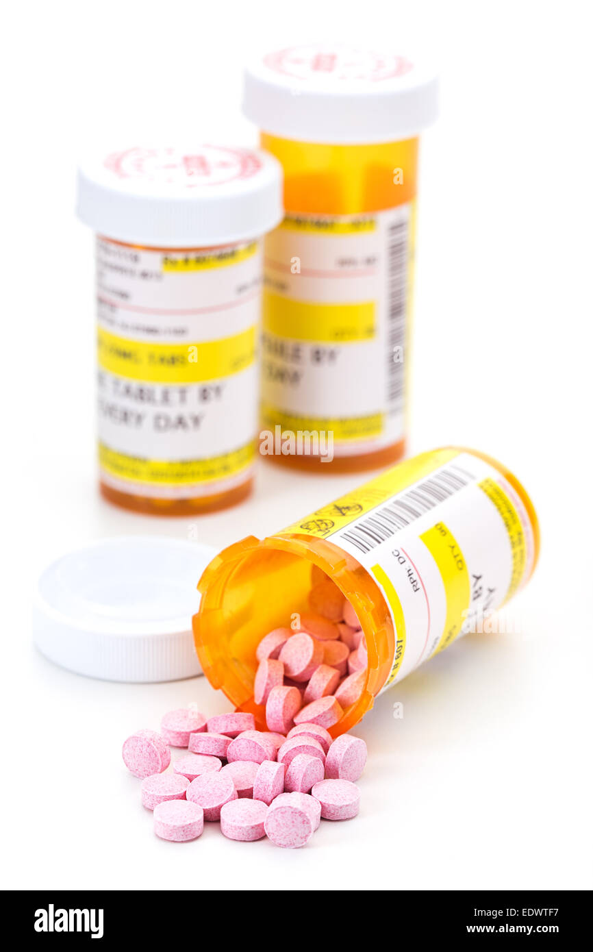 Prescription medication cascading out of orange pharmacy vials isolated ...