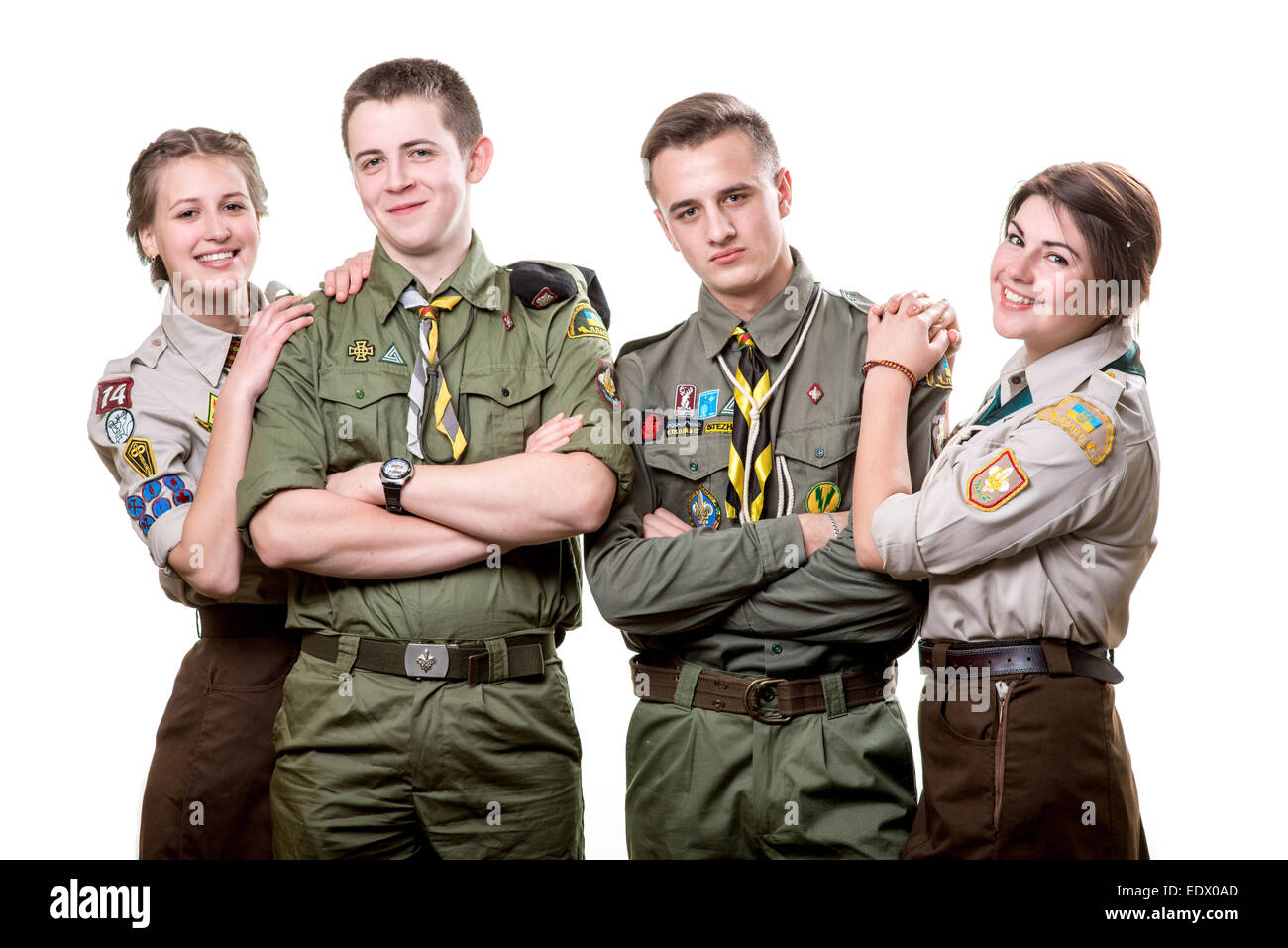 Four young scout members embracing in uniform isolated on white ...