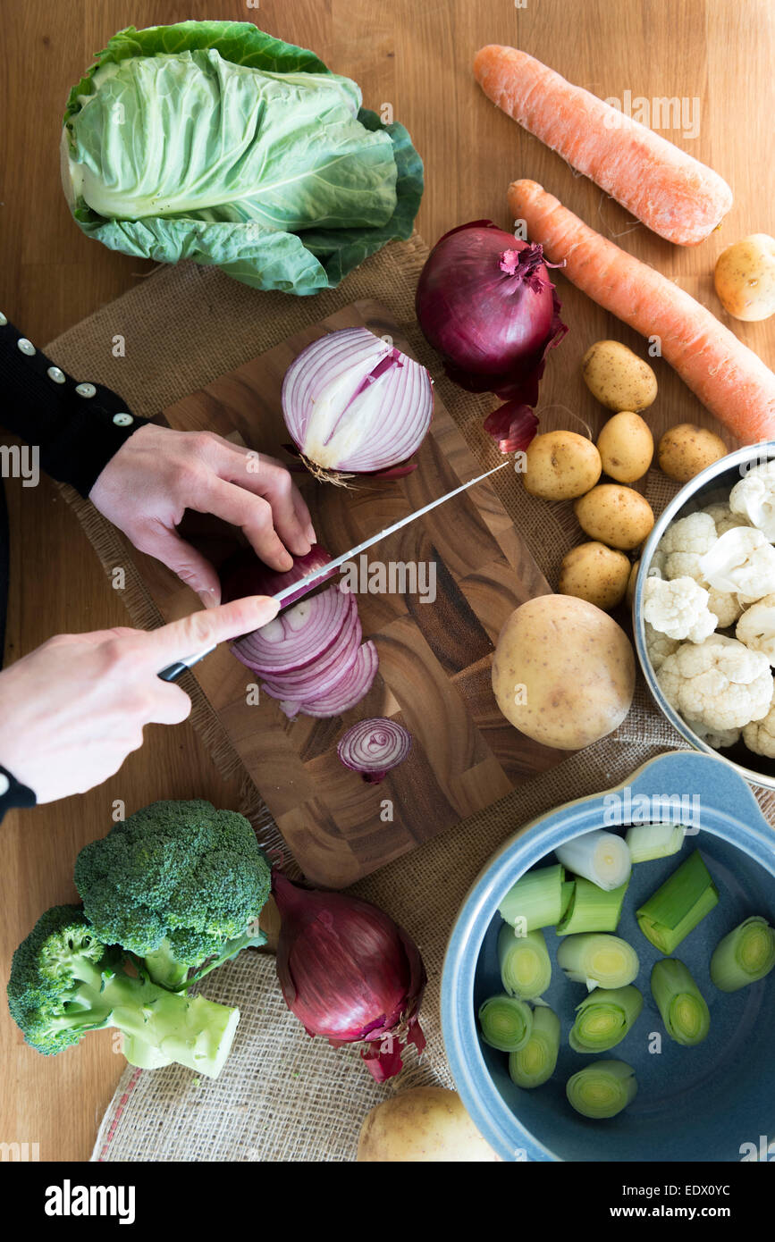 A womans hands slicing vegetables for a recipe Stock Photo - Alamy